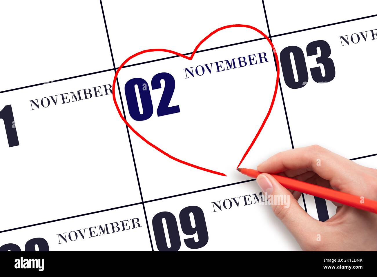 2nd day of November. A woman's hand drawing a red heart shape on the ...