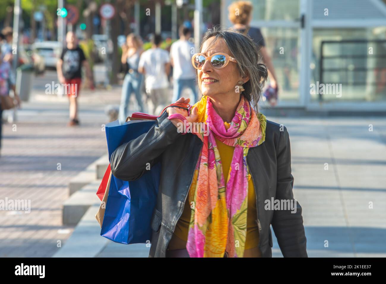 Senior attractive lady with shopping bags walking happy smiling in the ...