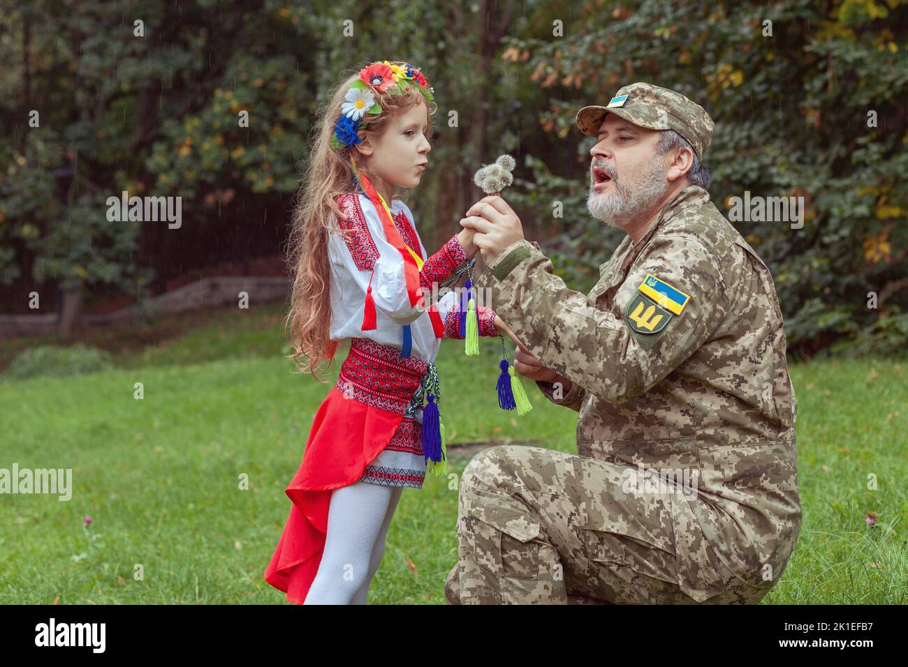 A little Ukrainian girl in a national costume meets her father from the ...