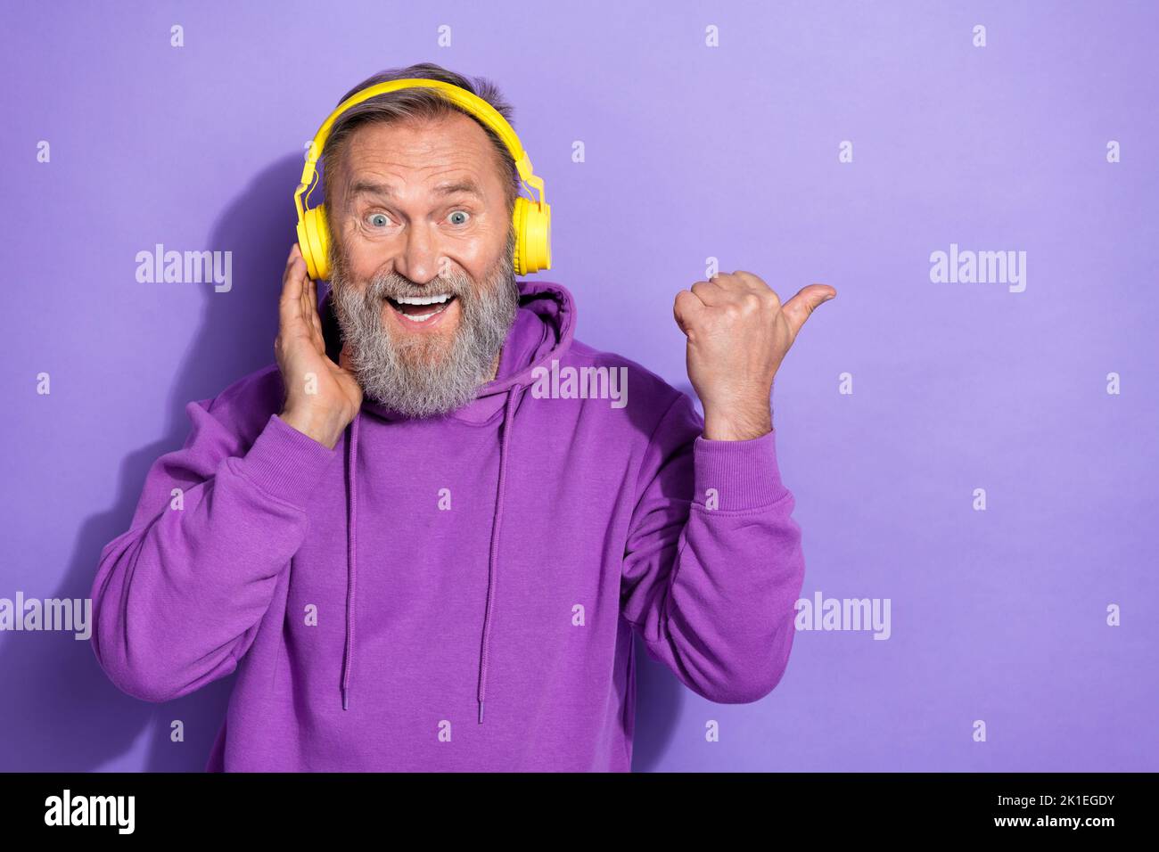 Portrait of healthy pensioner man purple hoodie touch headphones ...