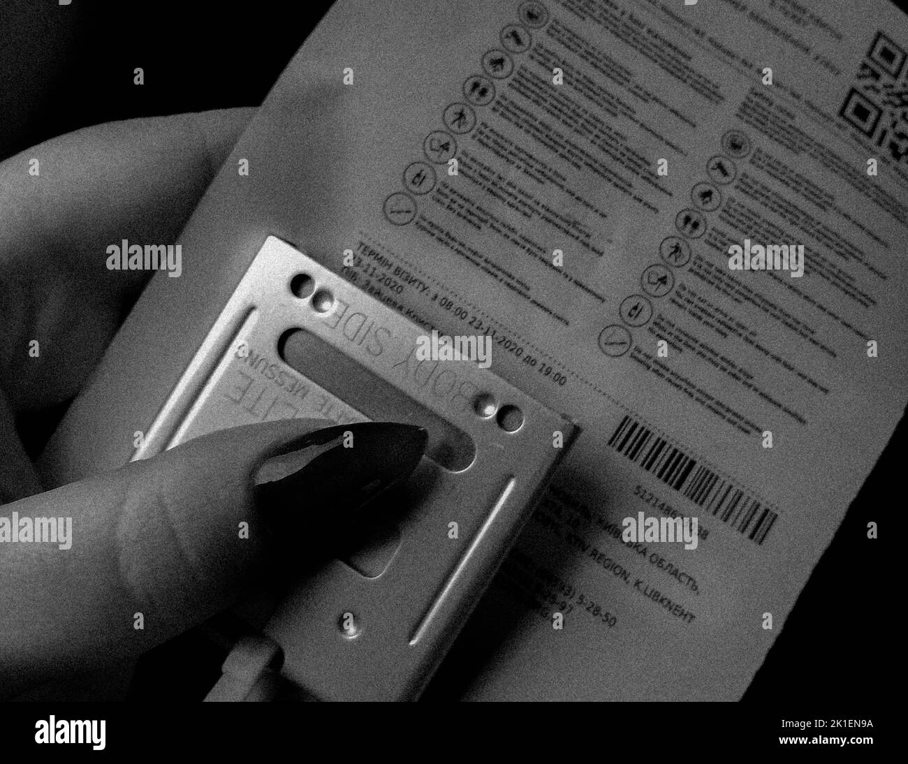A grayscale shot of a female hand holding a list with different ...