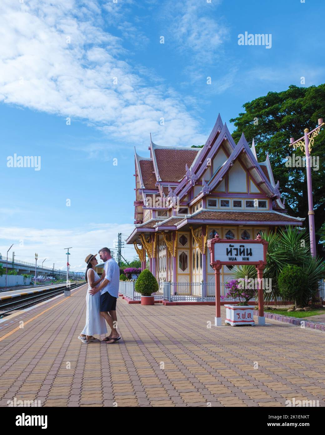 A couple of men and women are walking at Hua Hin train station in ...
