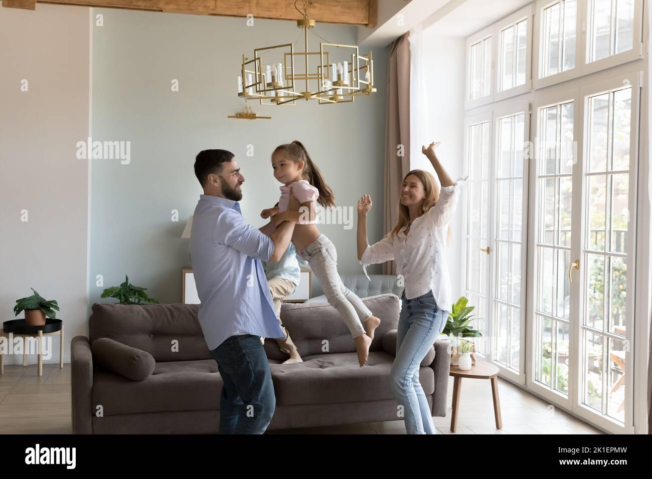 Cheerful excited parents and little daughter kid dancing to music Stock ...