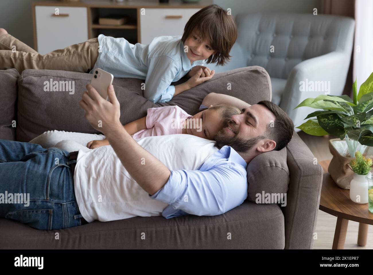 Happy relaxed dad and cheerful little sibling kids lying, hugging Stock ...