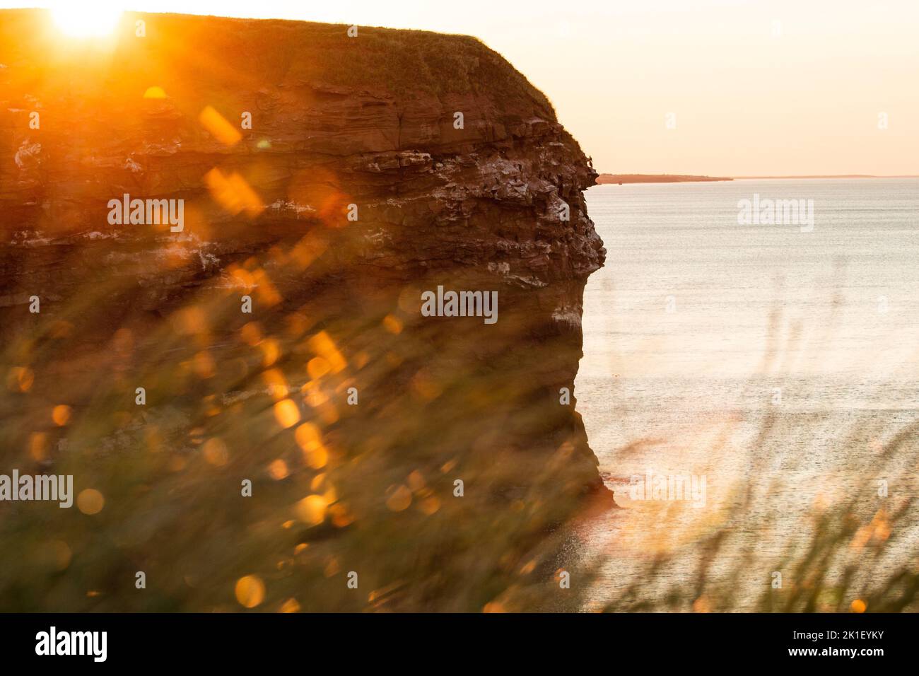 The view of the sunbeams behind the cliff. Cape Tryon, Prince Edward ...