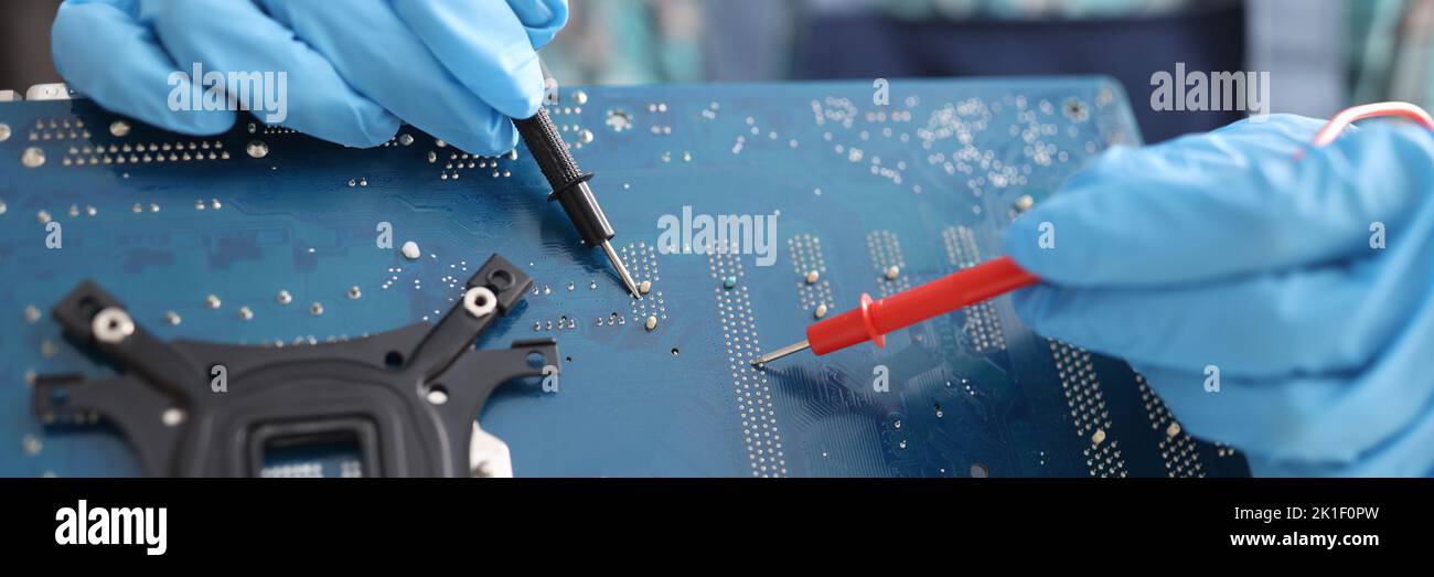 Repairman diagnosing breakdown in computer motherboard using tester ...
