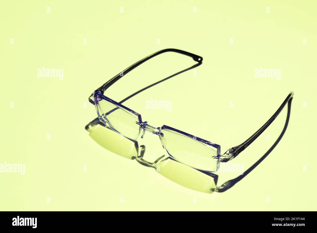Black framed eyeglasses on yellow background Stock Photo - Alamy