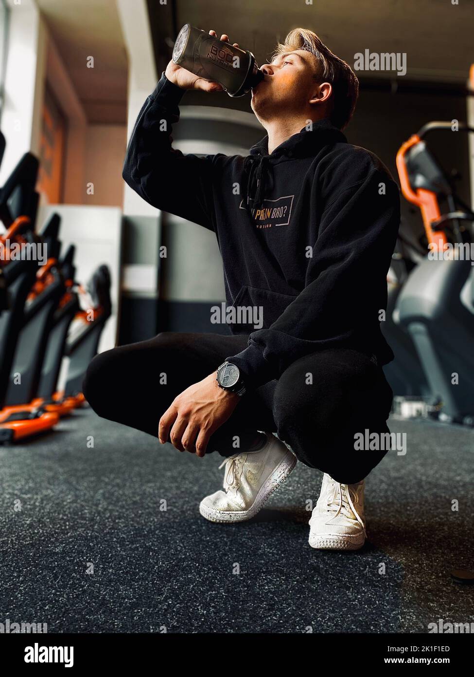 A vertical shot of a male athlete drinking his body nutrition shake ...