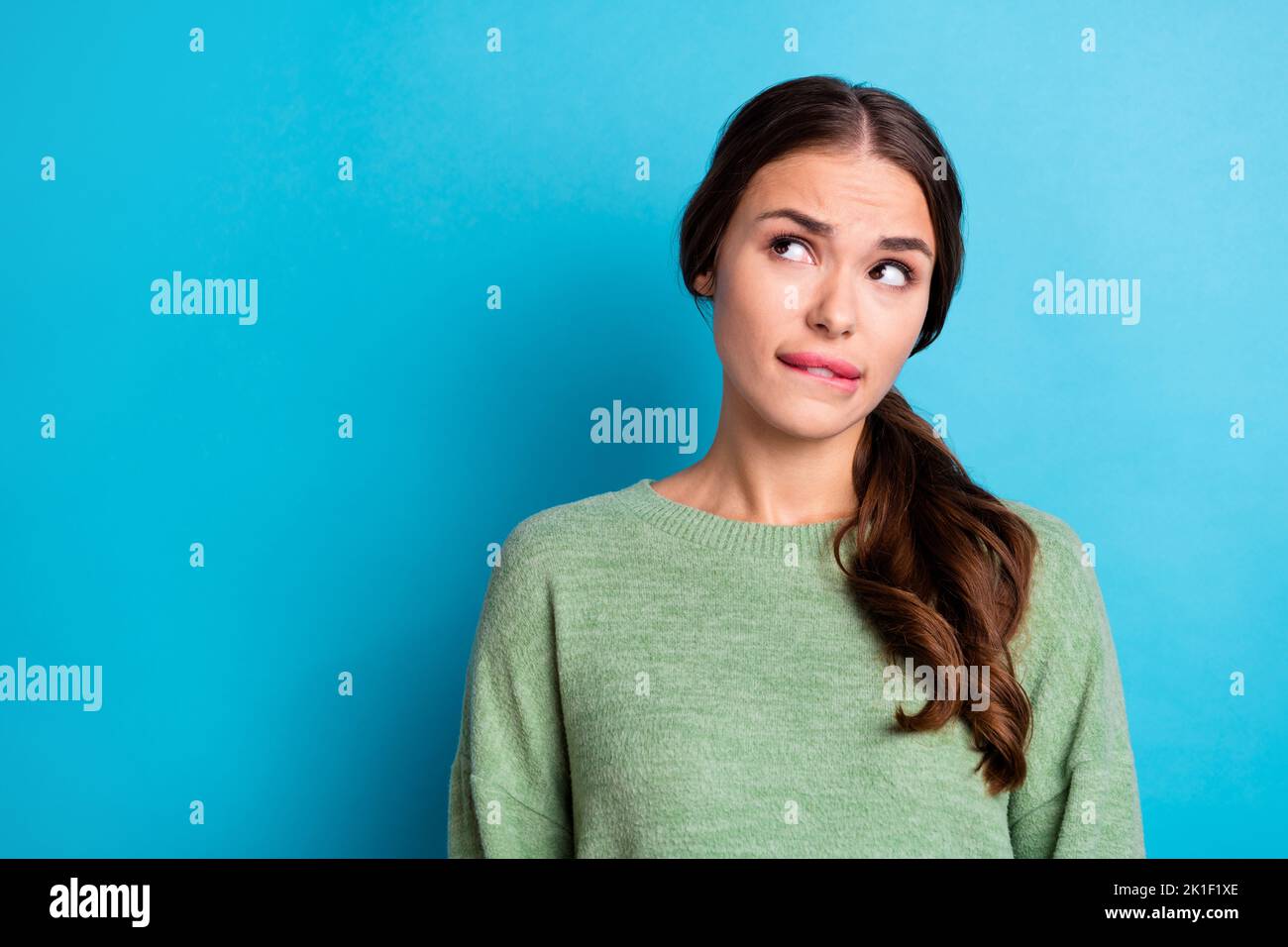 Portrait of pretty young person biting lips look empty space hesitate ...