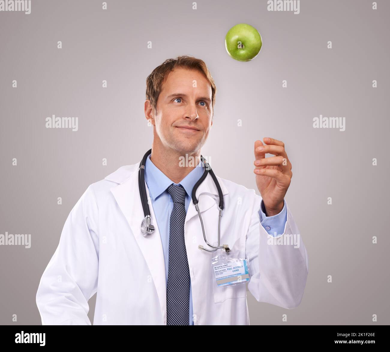 Hes a doctor with a healthy diet. A studio shot of a handsome doctor ...