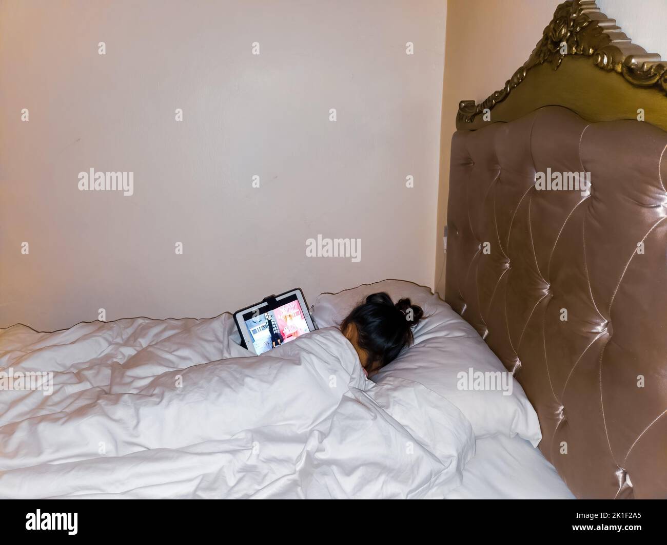 A child enjoying a children's story from the tablet during bedtime ...