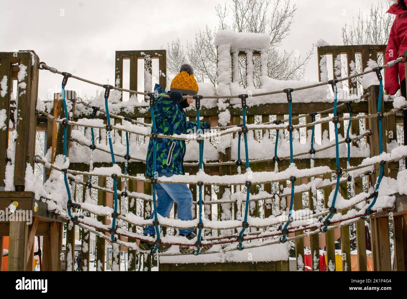 Little boy climbing a rope playground in winter Stock Photo - Alamy