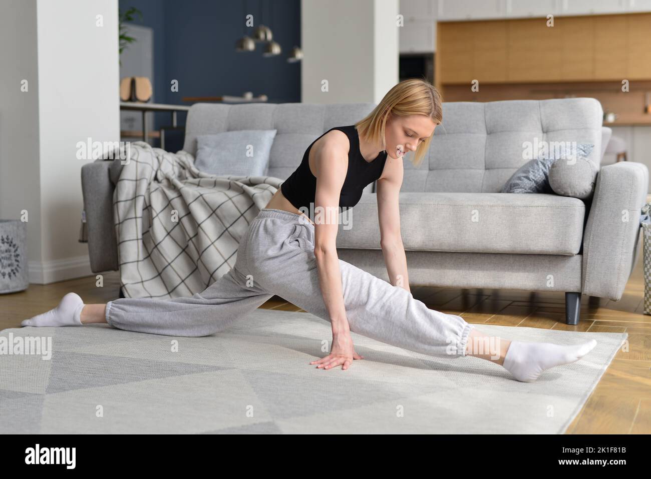 Woman working up forward splits warming up her legs Stock Photo - Alamy
