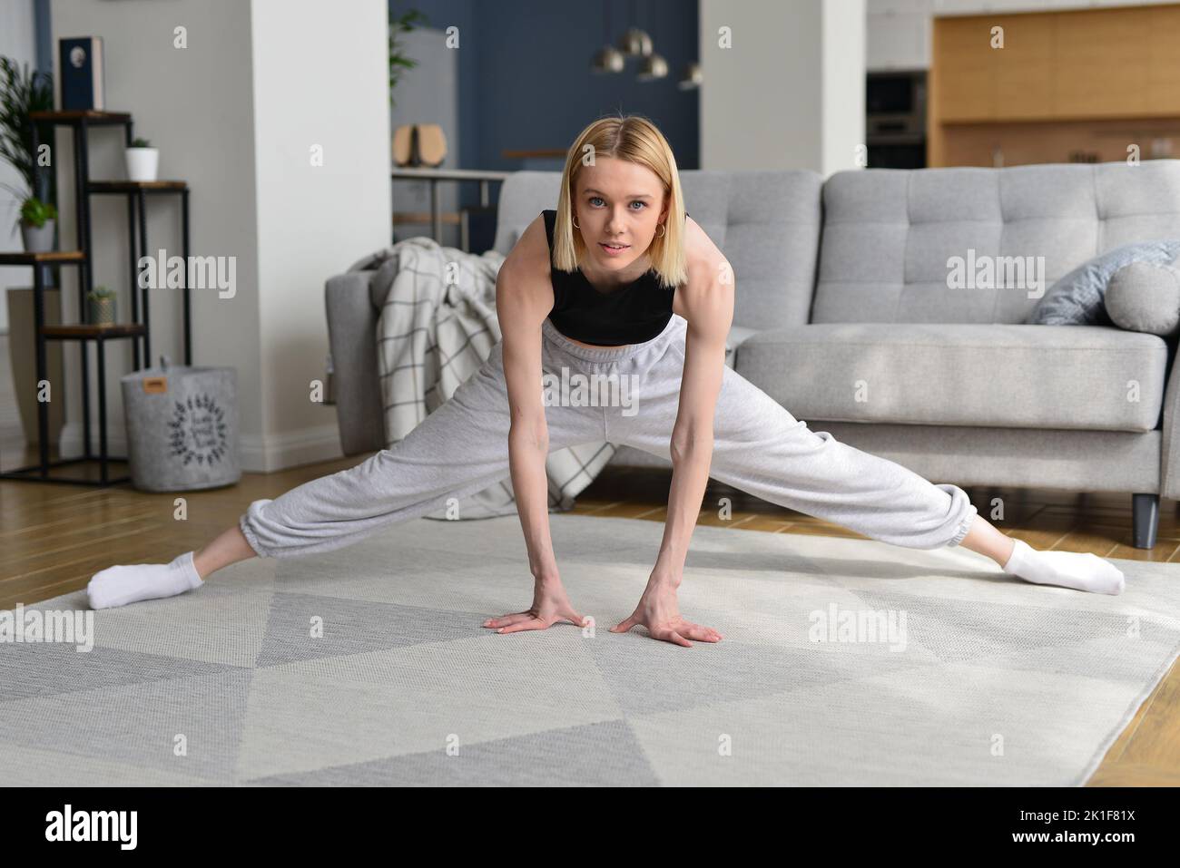Woman working up forward splits warming up her legs Stock Photo - Alamy