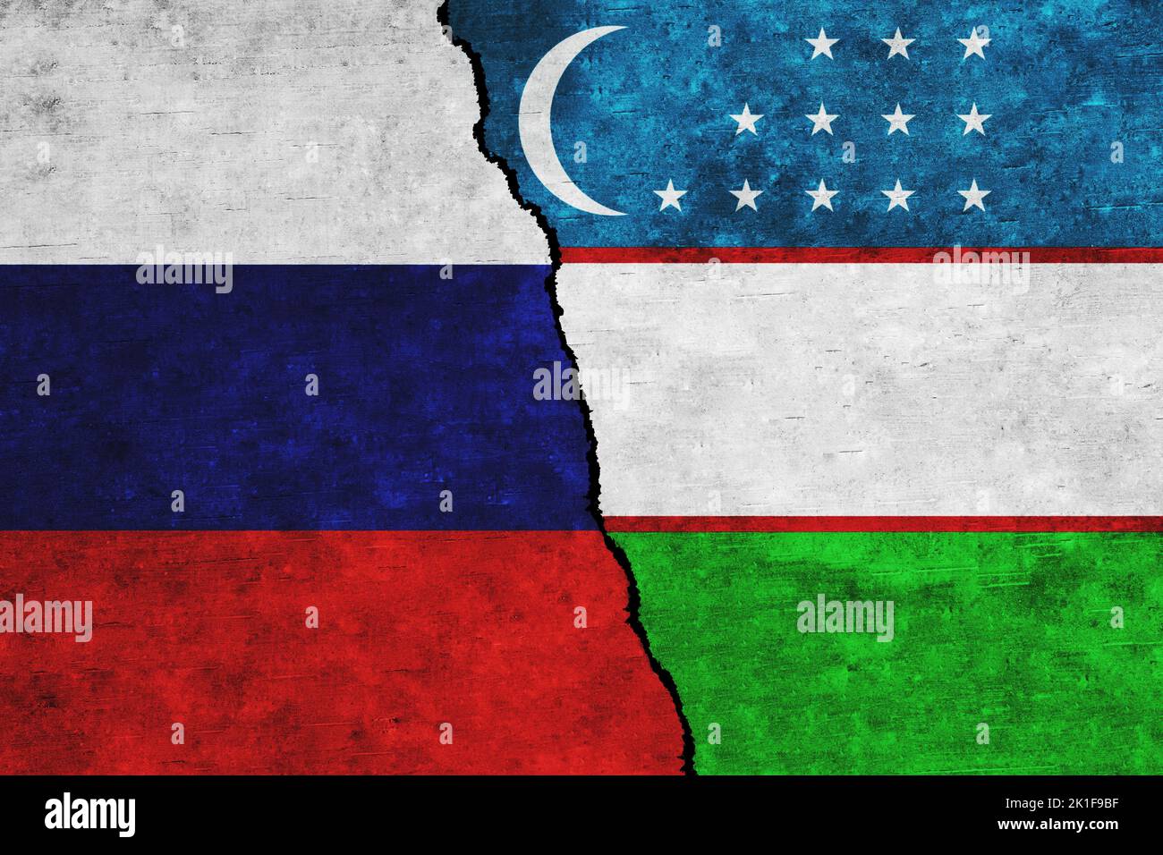 Russia and Uzbekistan painted flags on a wall with a crack. Russia and ...