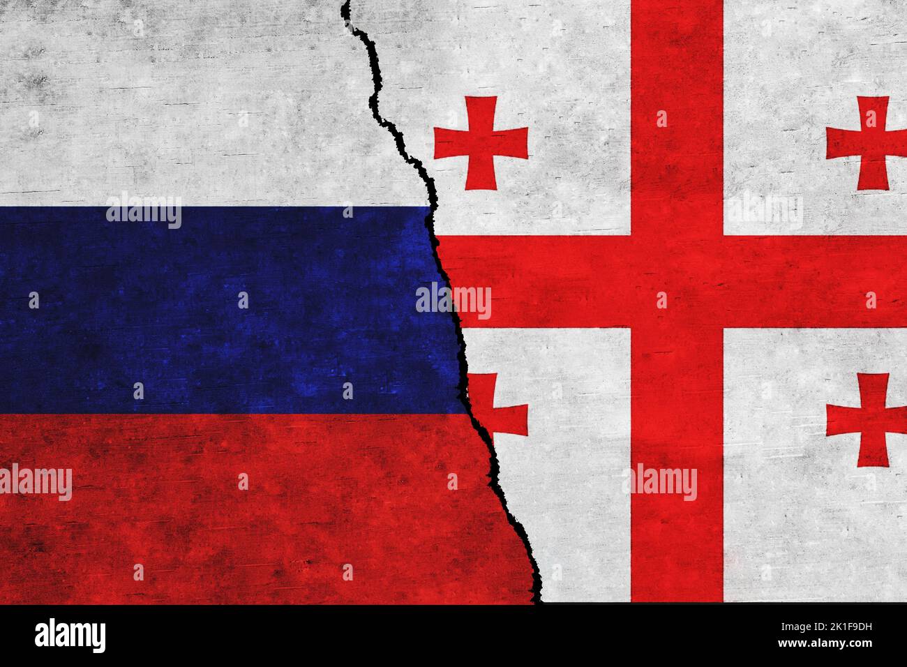 Russia and Georgia painted flags on a wall with a crack. Russia and ...
