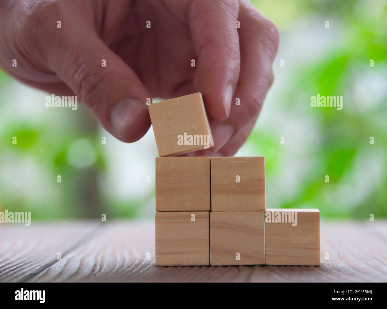 Hand holding empty wooden blocks with customizable space for text or ...