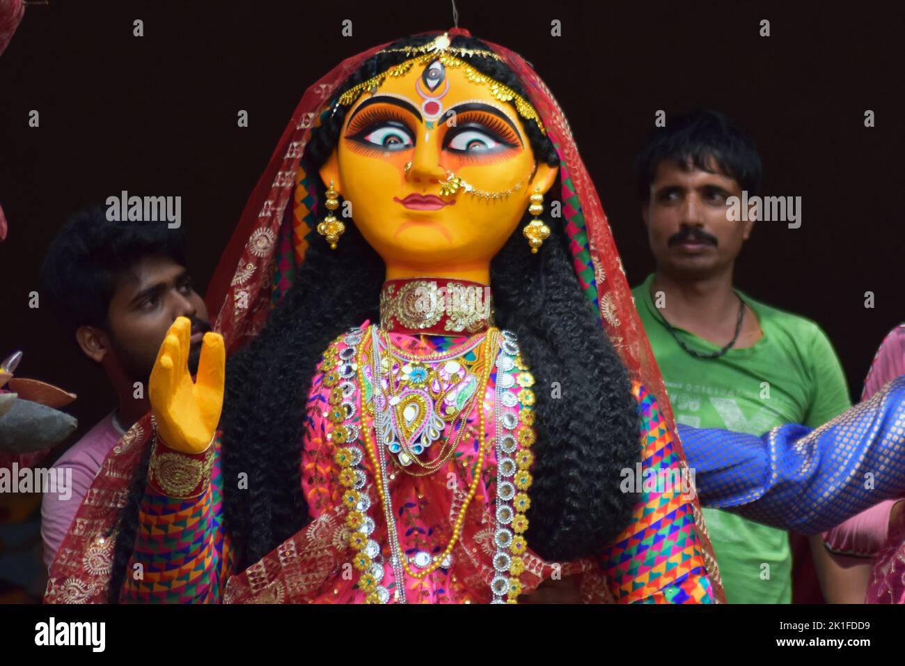An artisan is checking a puppet inside a pandal or a temporary platform ...