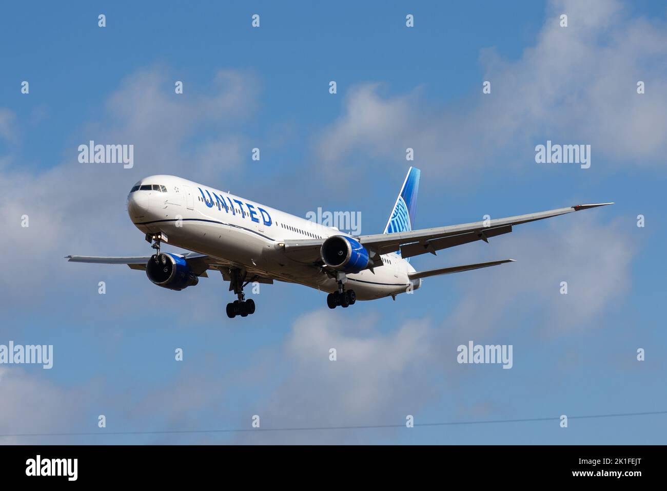 A United Airlines Boeing 767-424 isolated in the air with clouds in the ...