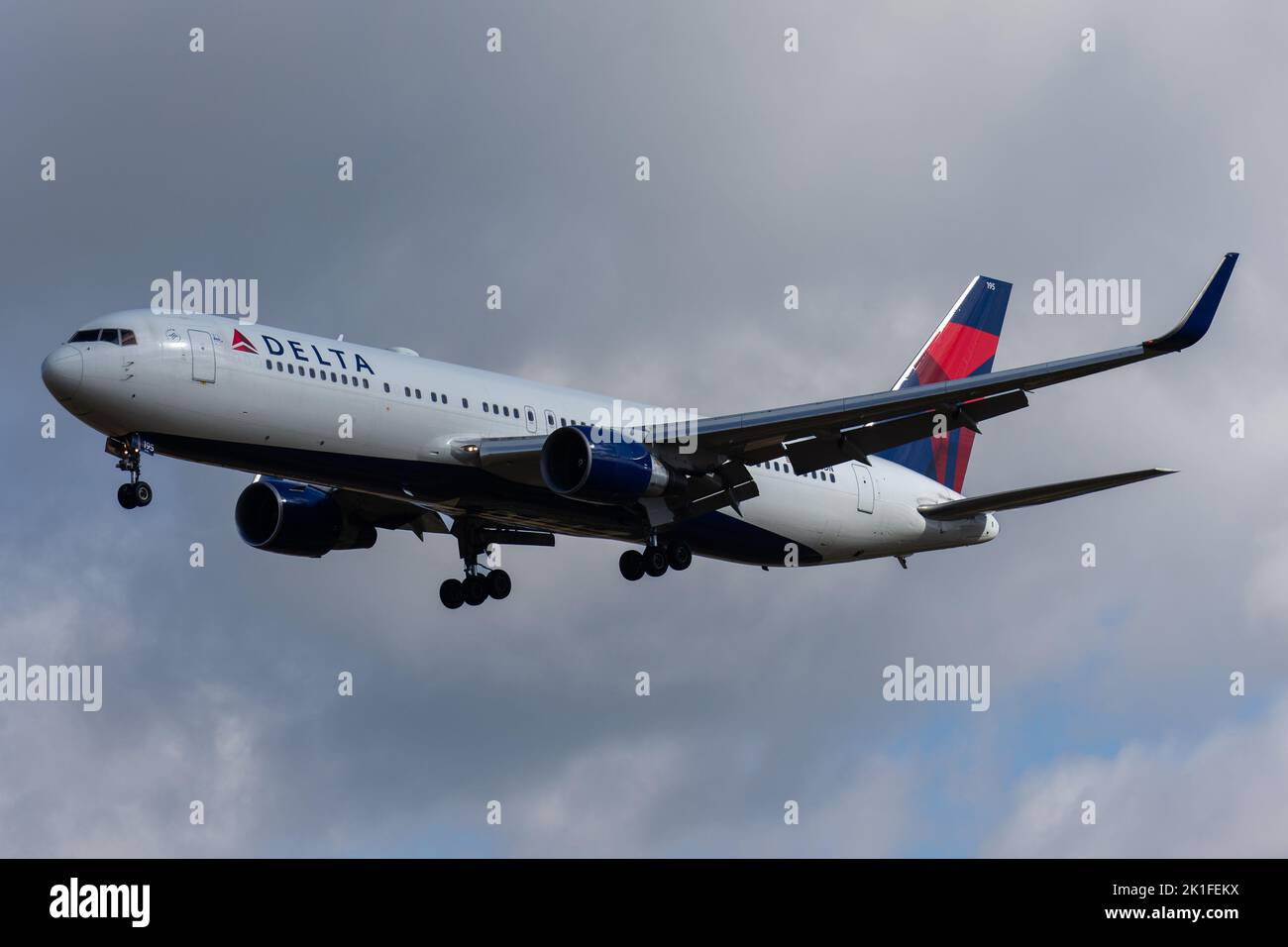 A Delta Airlines Boeing 767-332 isolated in the air with clouds in the ...