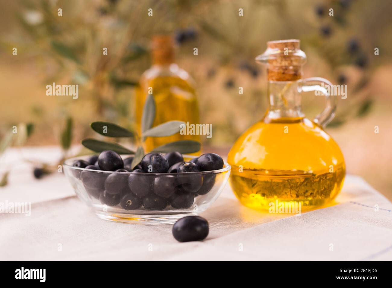 still life of olives and oil on a table against a background of olive ...
