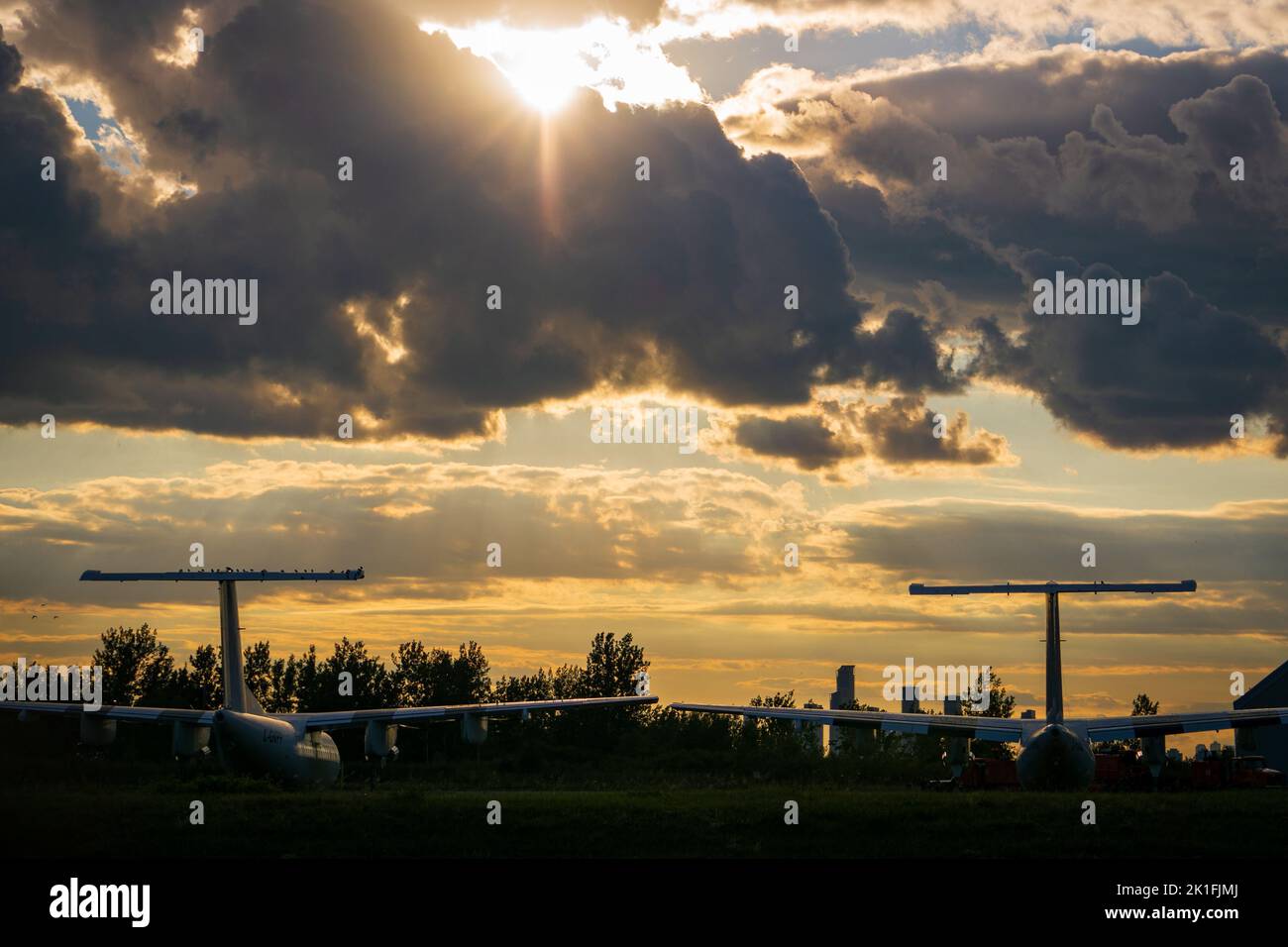 A bright beautiful sunset sky over the runway with planes at the ...