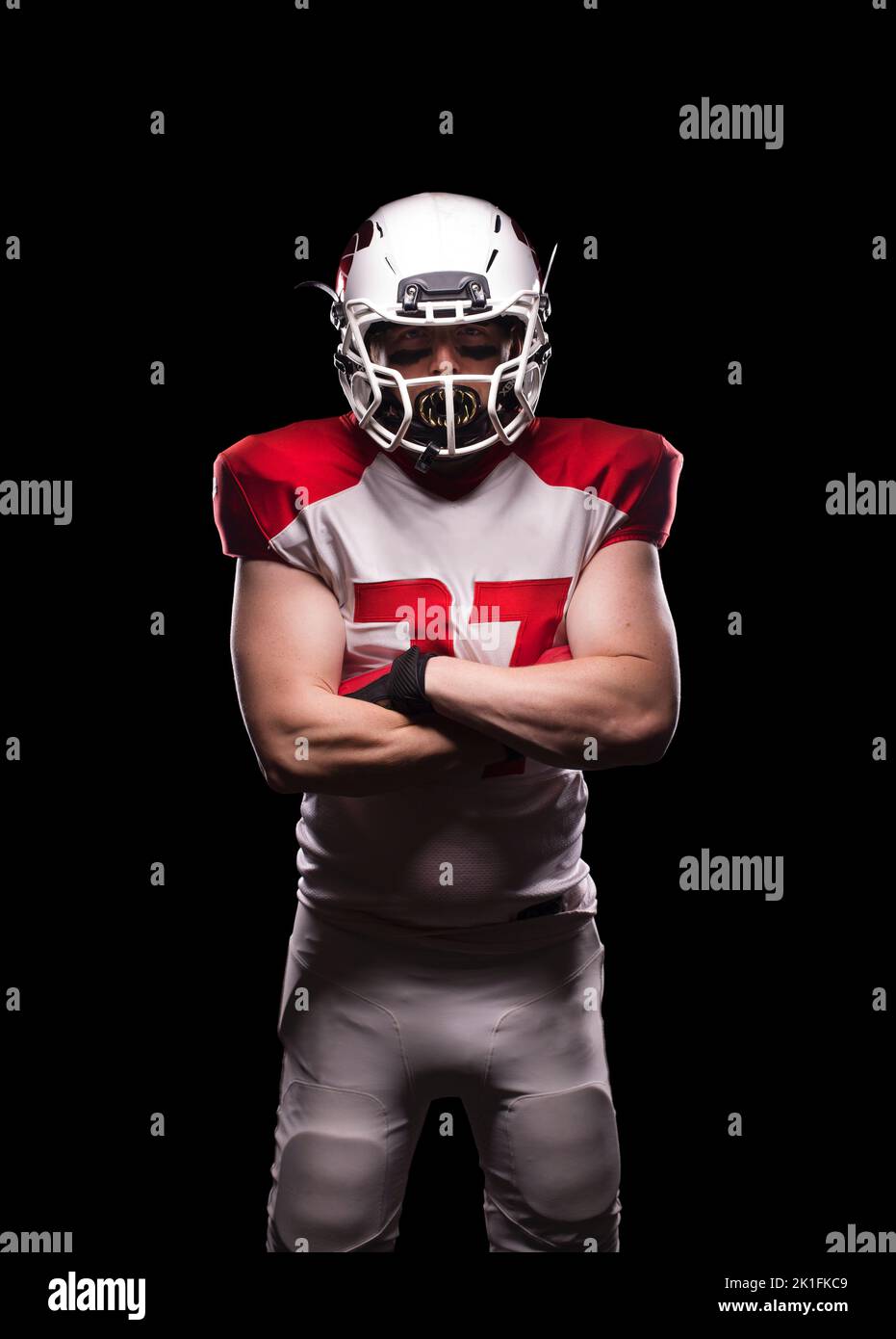 Male in American football attire with arms folded Stock Photo - Alamy