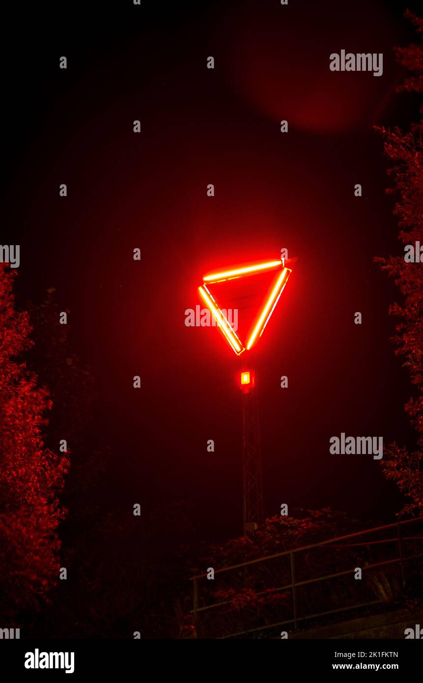Big red triangle glowing I the dark night Stock Photo - Alamy