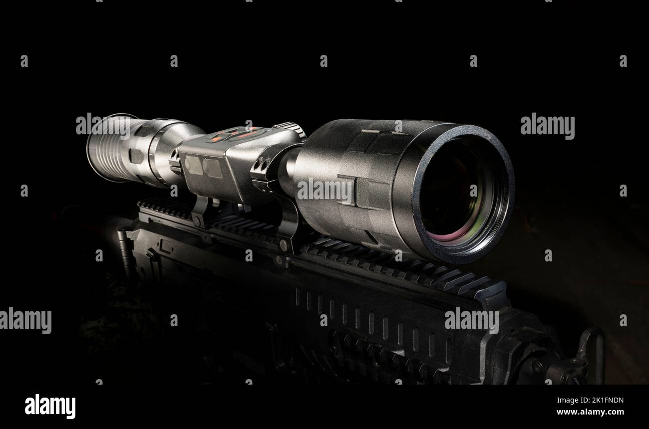 Infrared night vision scope mounted on a rifle with dark background ...