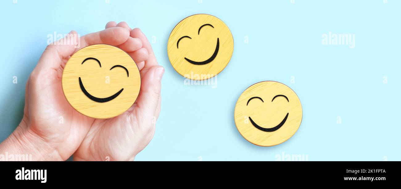 Hand holding happy smile face on blue background, Positive thinking ...