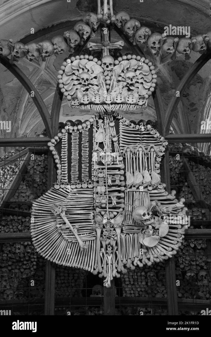 A grayscale shot of an art sculpture made of human bones in the Sedlec ...