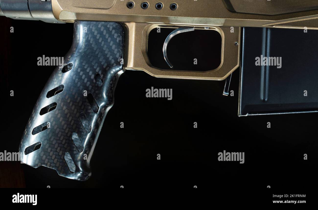 Trigger with pistol grip and magazine on a rifle on a black background ...