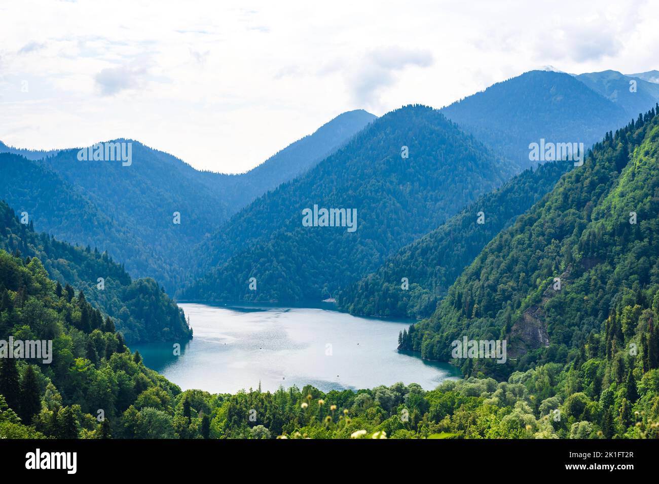 Mountain steep hills with green forests surround Lake Ritsa Stock Photo ...