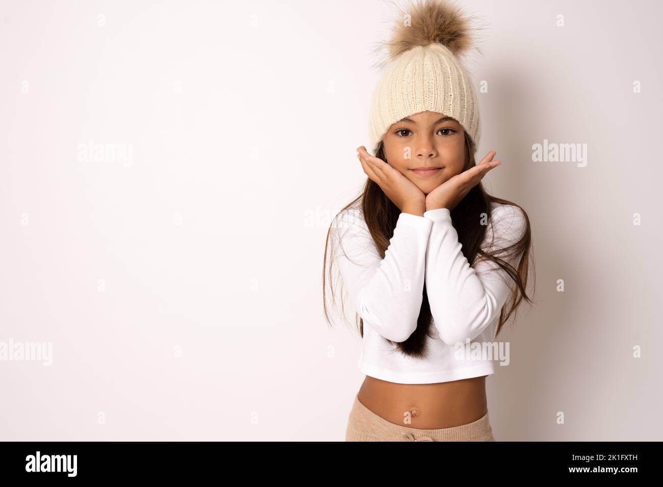 Little beautiful happy girl wearing cute winter hat smiling looking confident at the camera ...