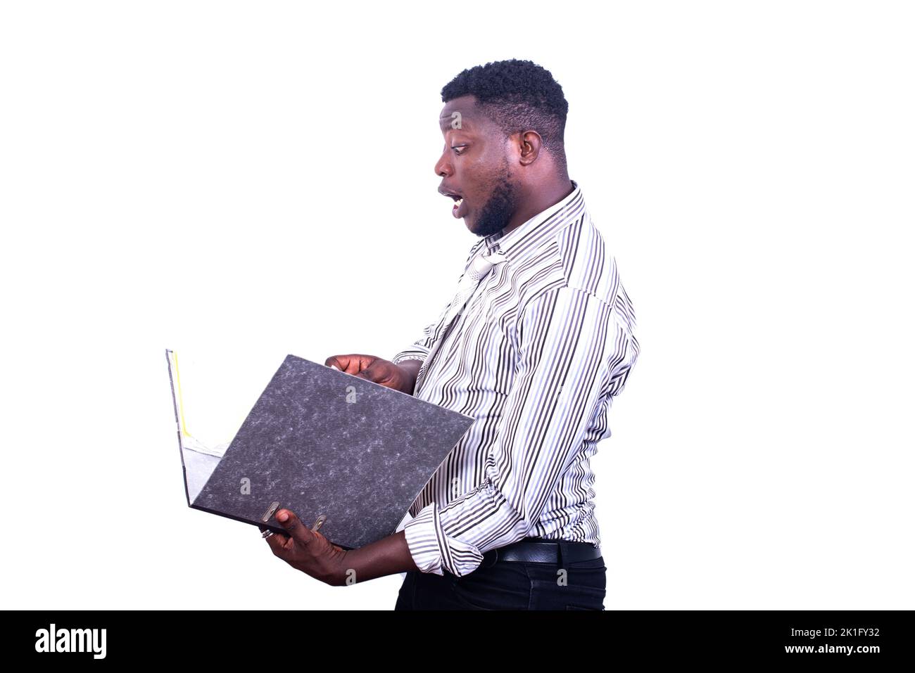 young surprised businessman standing reading files in a filing cabinet ...