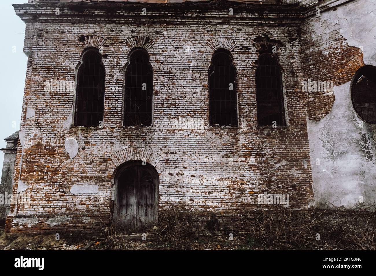 Haunted catholic church and broken windows, bleak white-red bricks, and ...