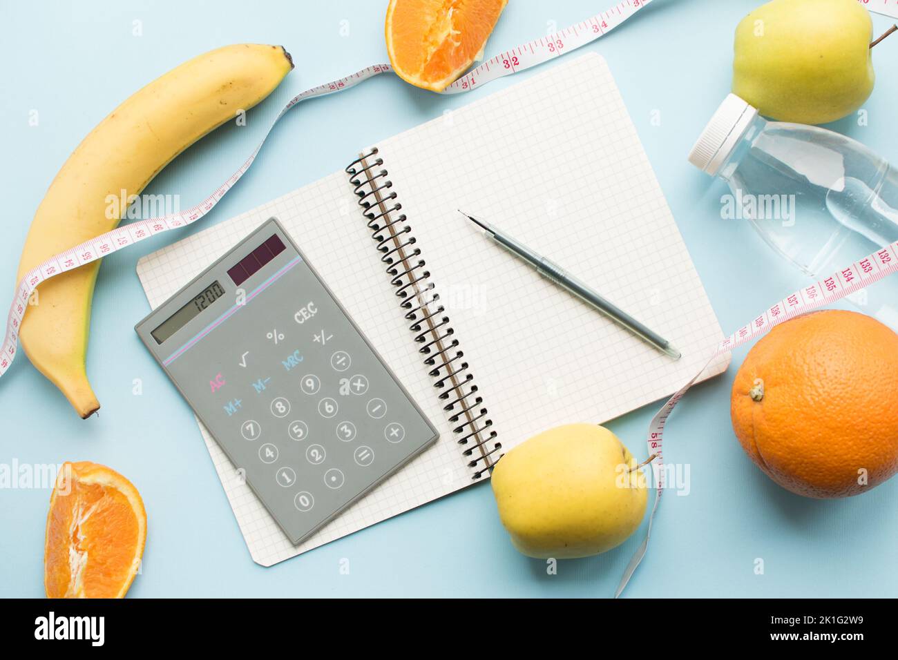 Empty paper notebook, calculator with numbers 1200, pen, bottle of ...