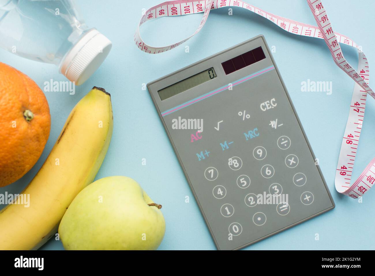 Calculator, bottle of water, measuring tape and fruits on blue ...