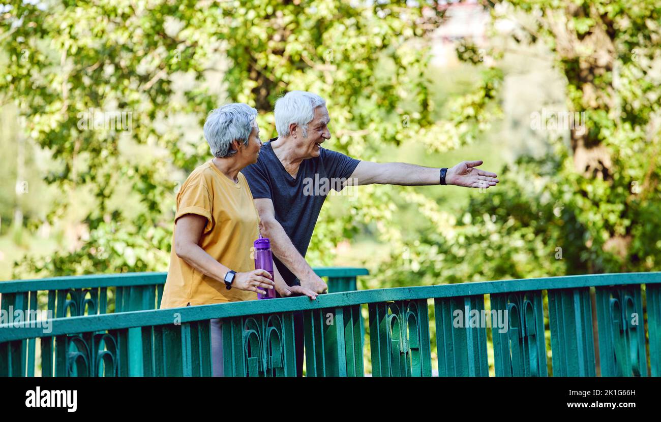 Attractive middle-aged old couple, wife and husband enjoy a walk and ...