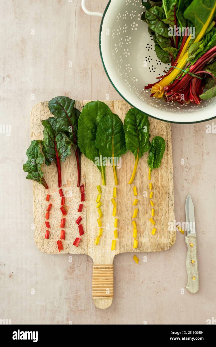 A flat lay of colorful cut stems of Chard vegetables on a wooden ...