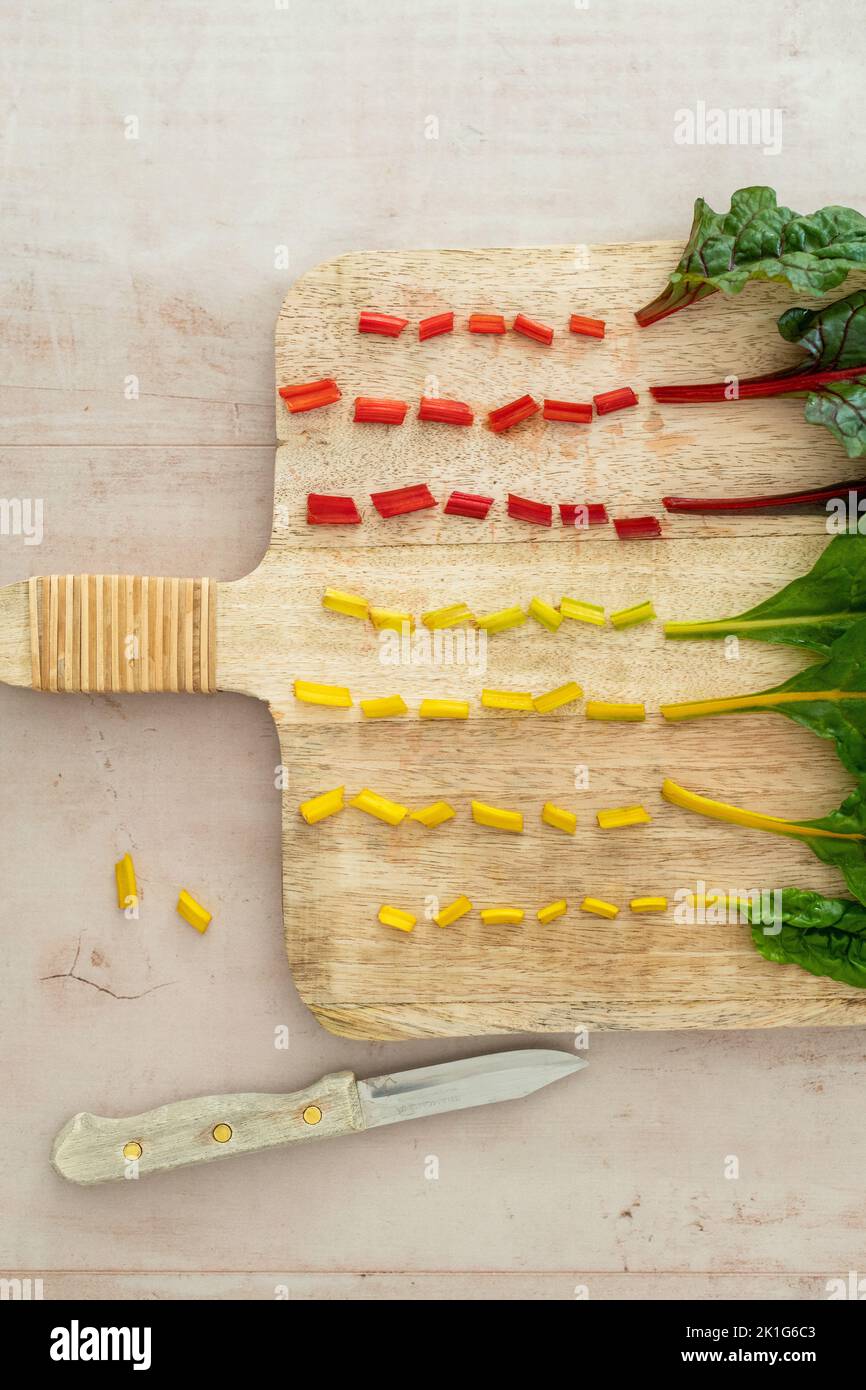 A flat lay of colorful cut stems of Chard vegetables on a wooden ...