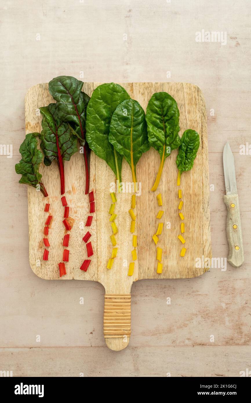 A flat lay of colorful cut stems of Chard vegetables on a wooden ...