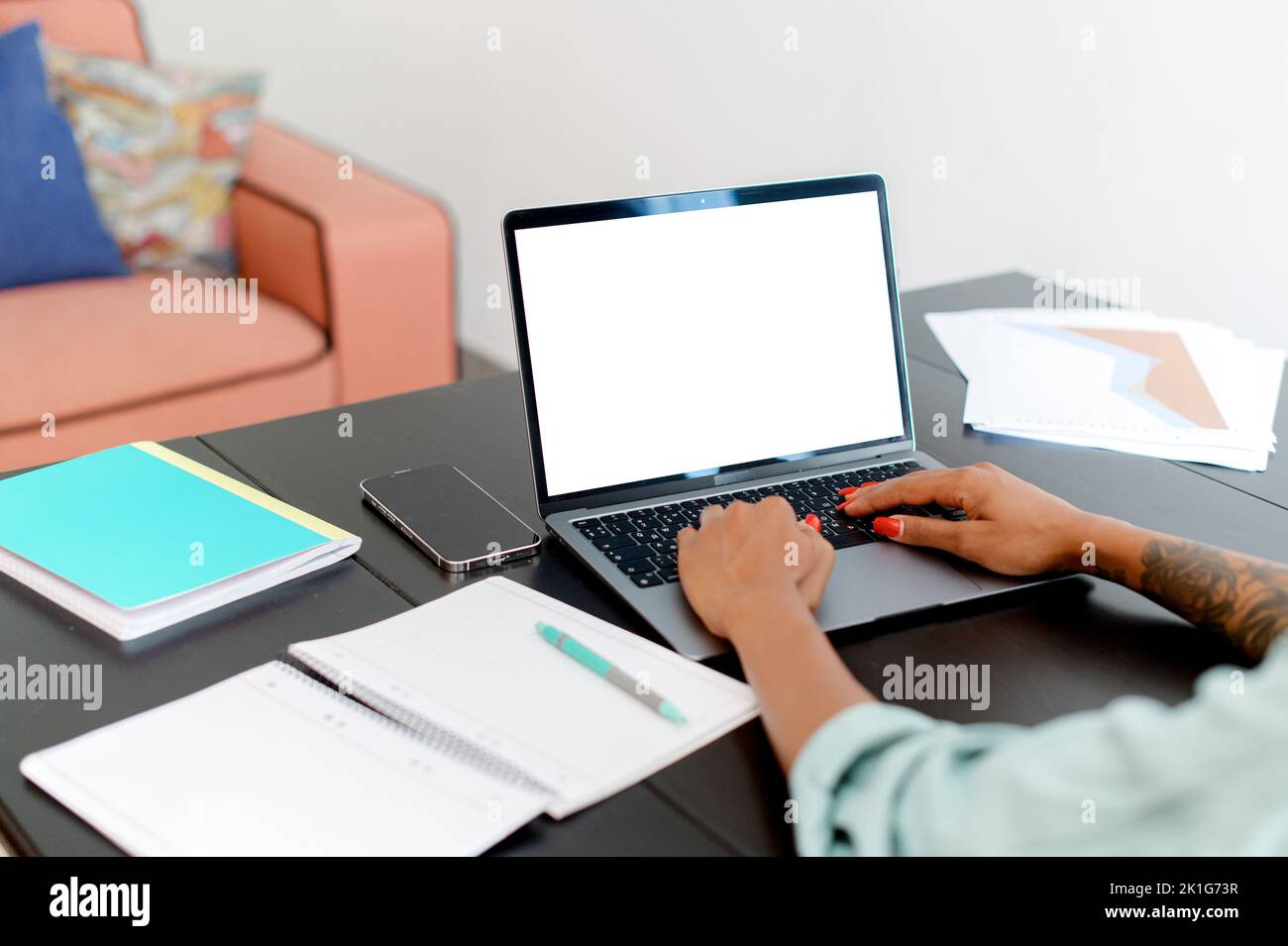 Photo over the shoulder of the woman sitting in front of laptop and ...