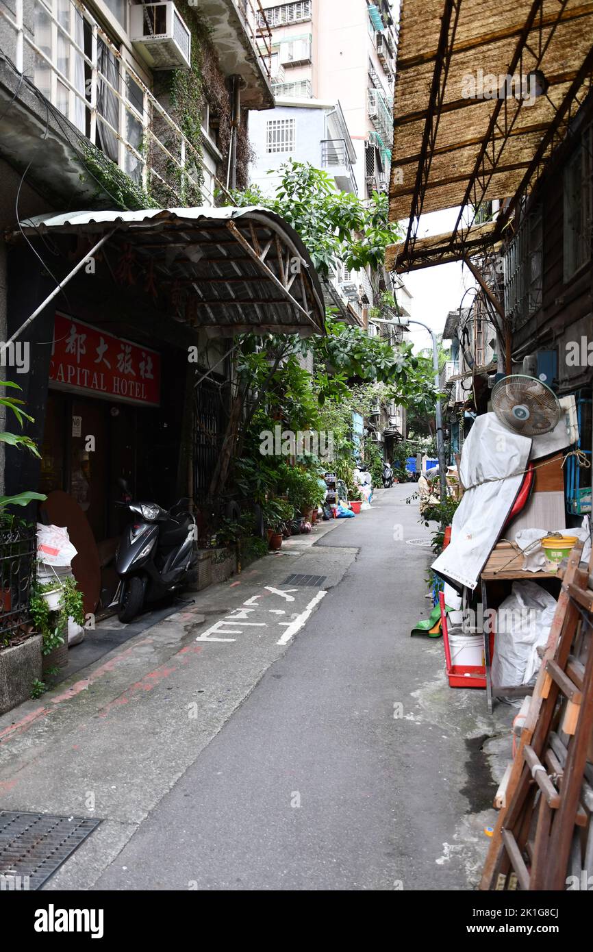 A vertical shot of a small alley between residential buildings with ...