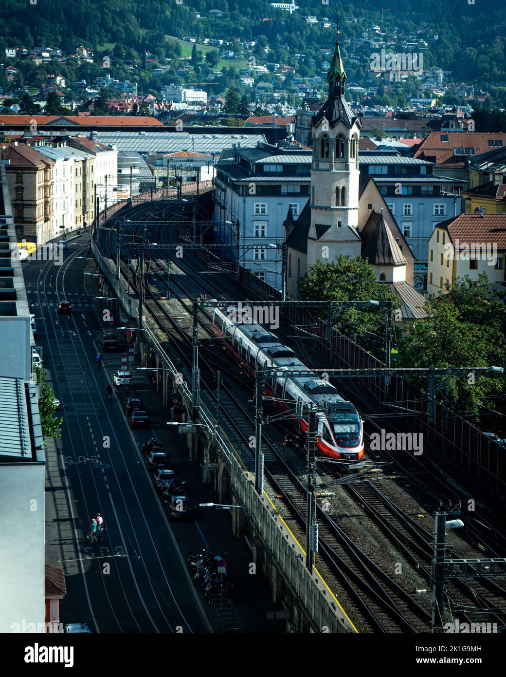 A Vertical Shot Of A Train On A Train Track Crossing From A City Stock