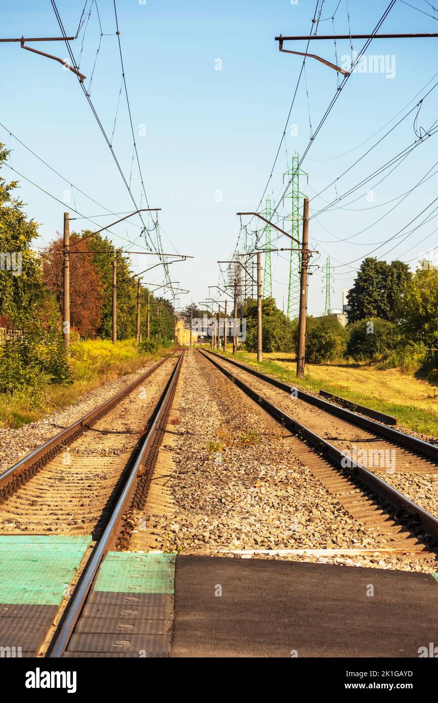 Old rusty train metal rails with blue sky and green trees Stock Photo ...