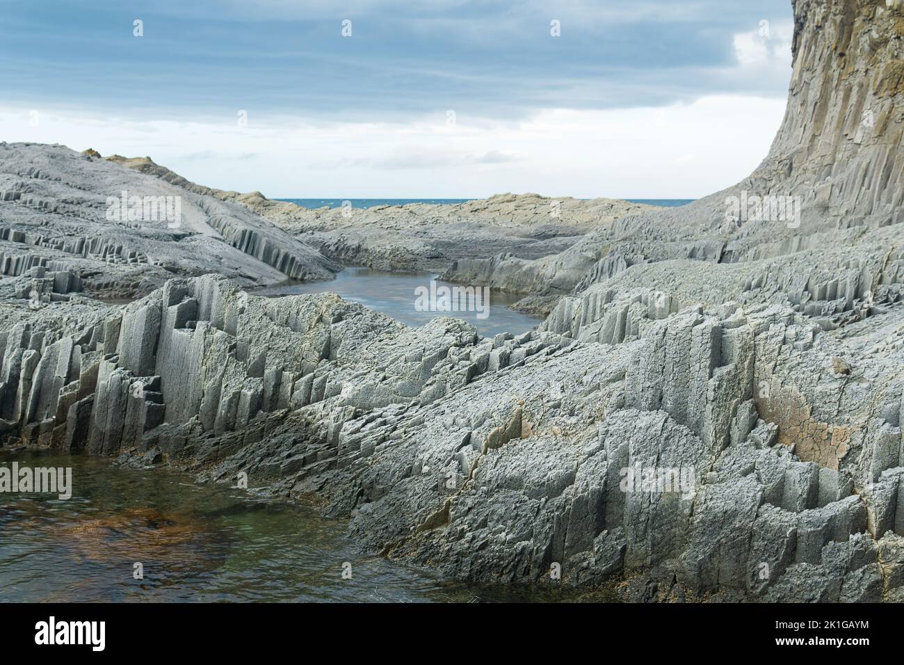 coastal cliffs formed by columnar basalt at low tide Stock Photo - Alamy