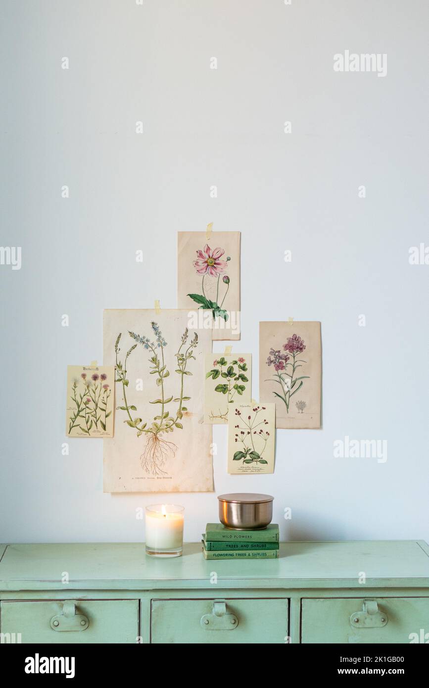 A vertical shot of a scented candle on top of stacked books with ...