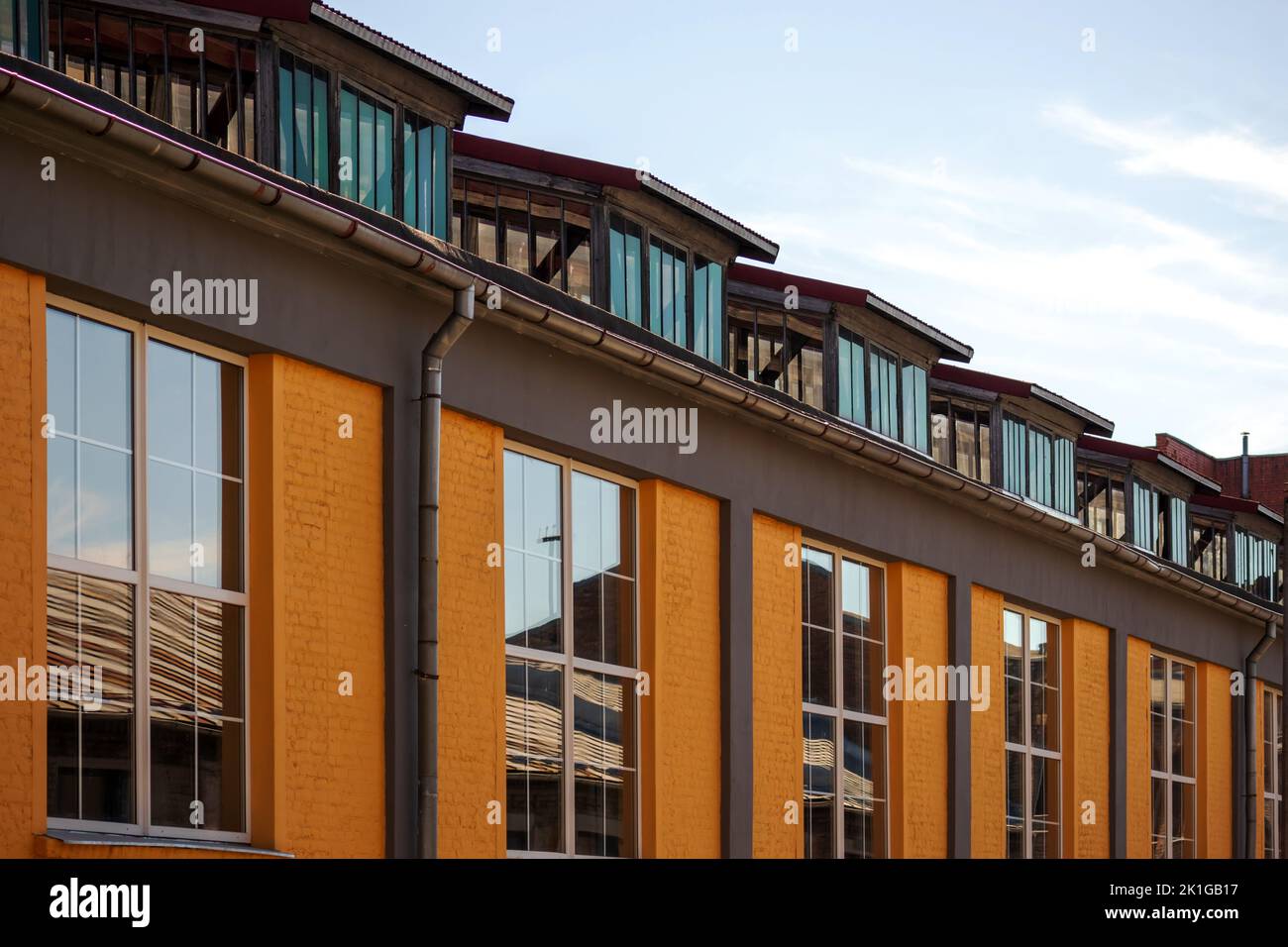 An orange building with many blue windows with blue sky in the middle ...