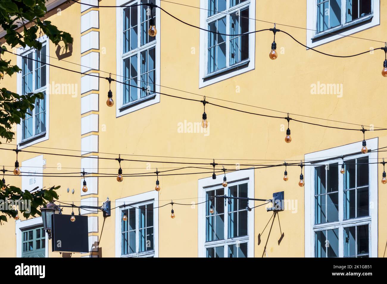 A bright yellow building with black lights hanging over the streets ...